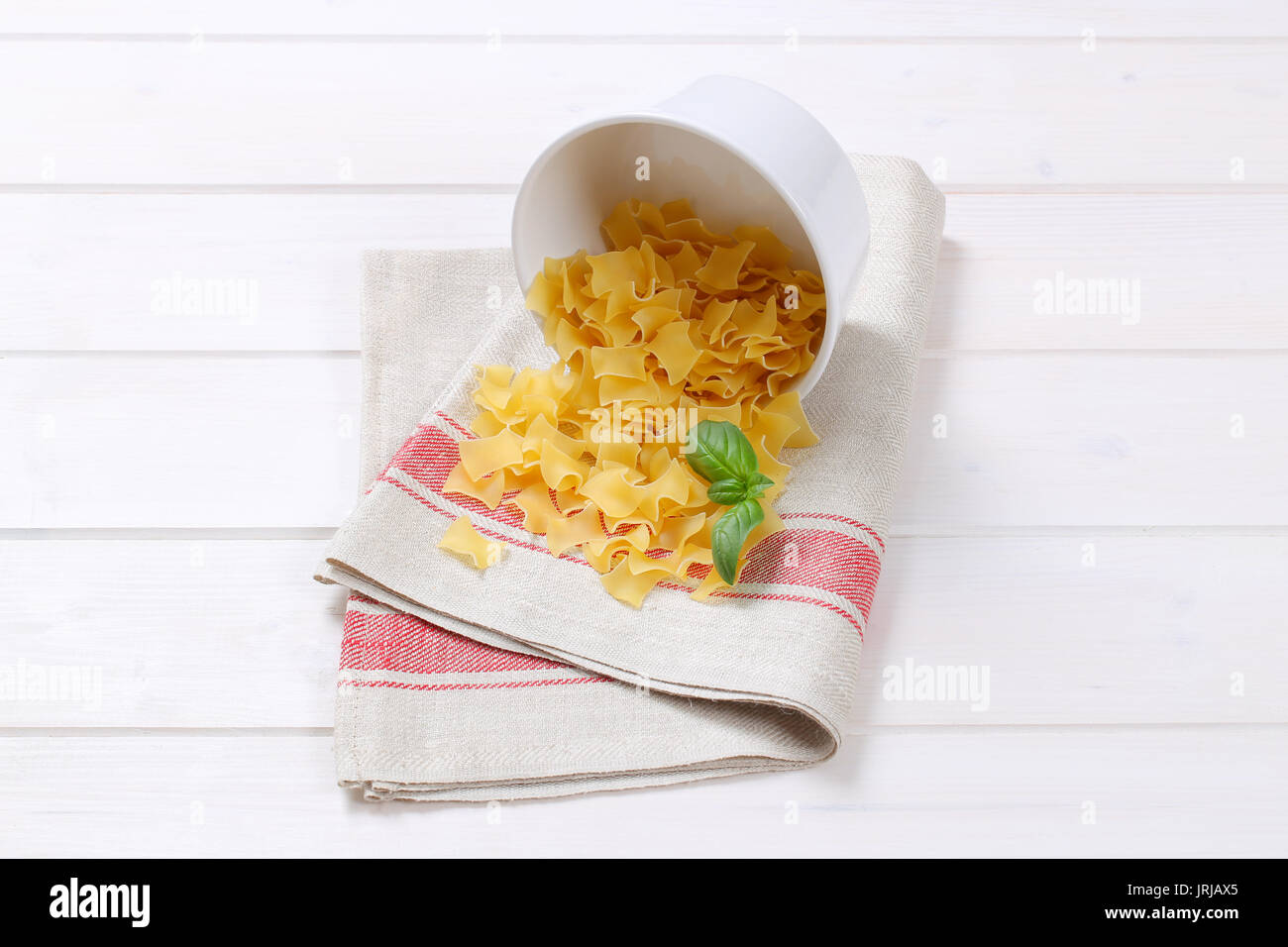 bowl of quadretti - square shaped pasta spilt out on place mat Stock ...