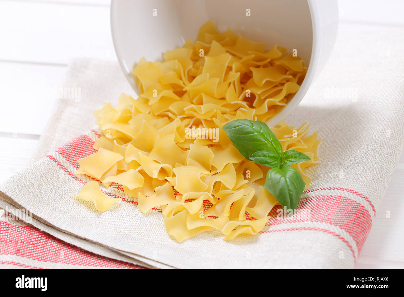 bowl of quadretti - square shaped pasta spilt out on place mat - close ...
