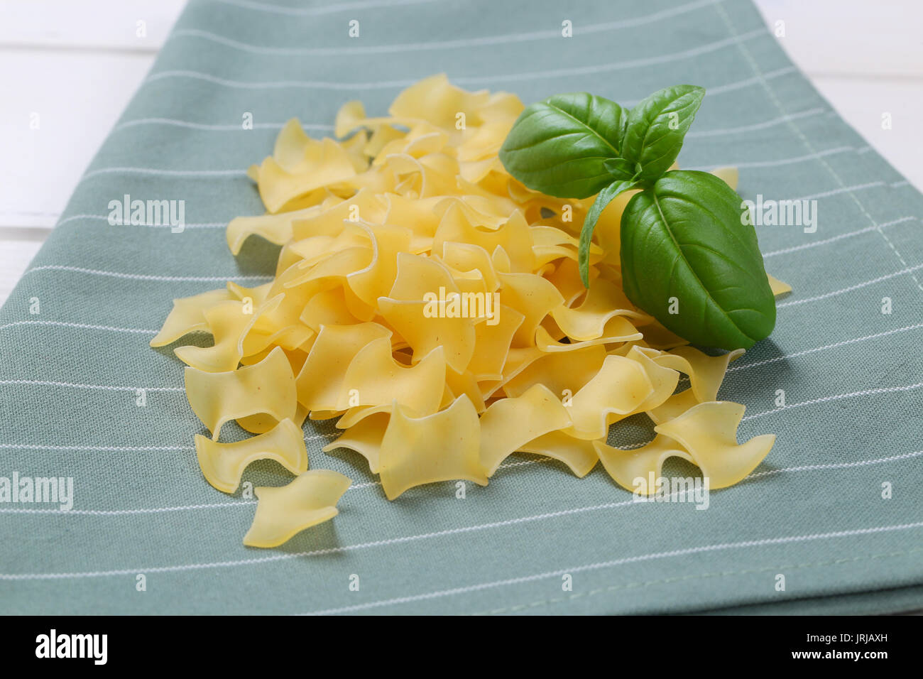 pile of quadretti - square shaped pasta on grey place mat - close up ...