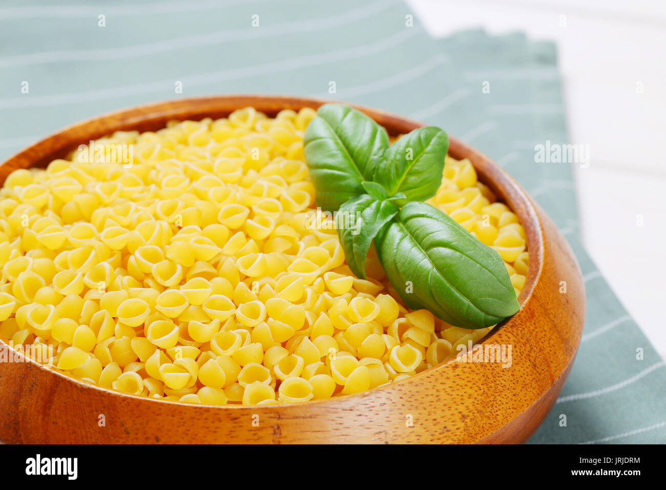 bowl of small pasta shells on grey place mat - close up Stock Photo - Alamy