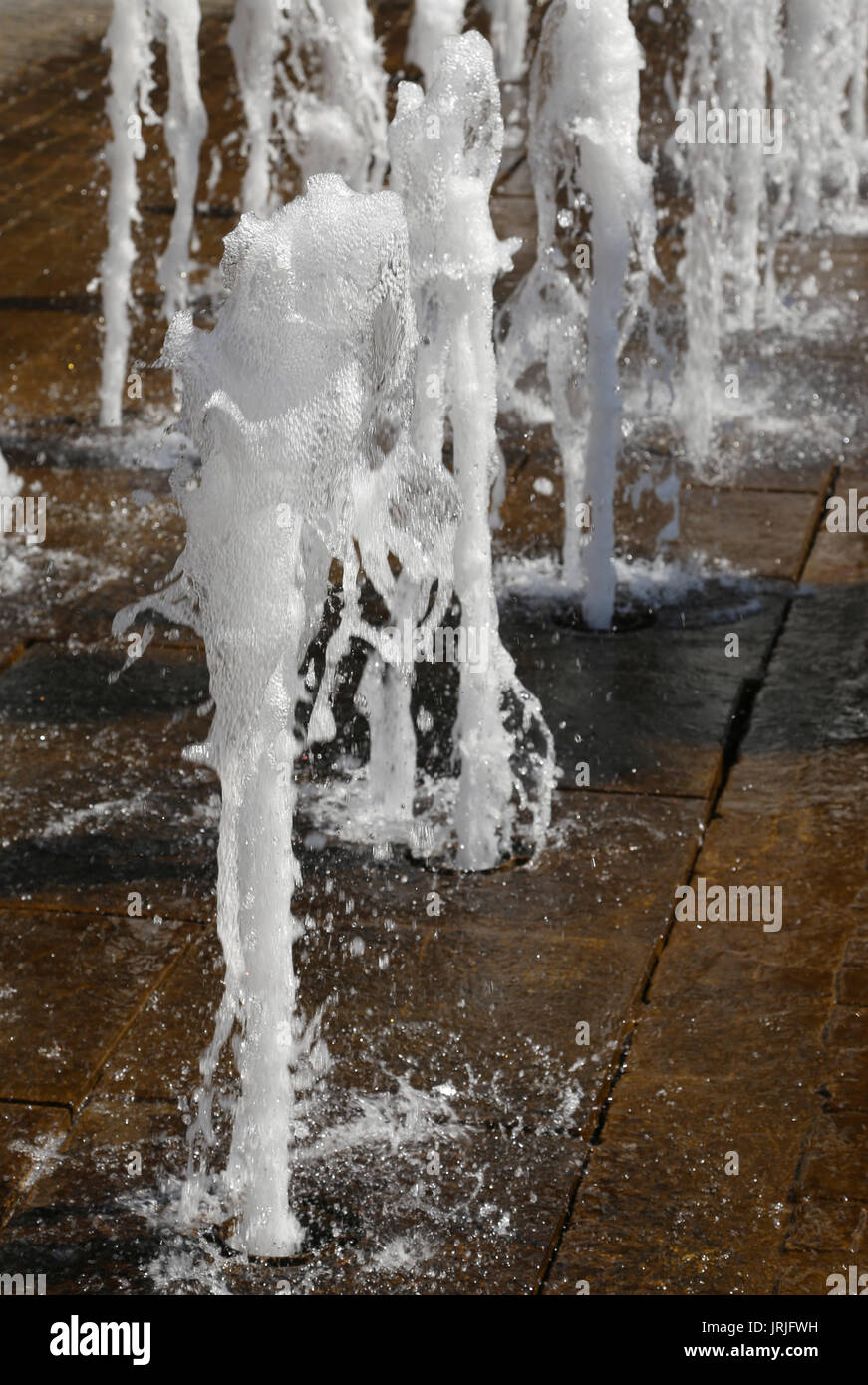 White sparkling fountain splashes in summer in a city Stock Photo - Alamy