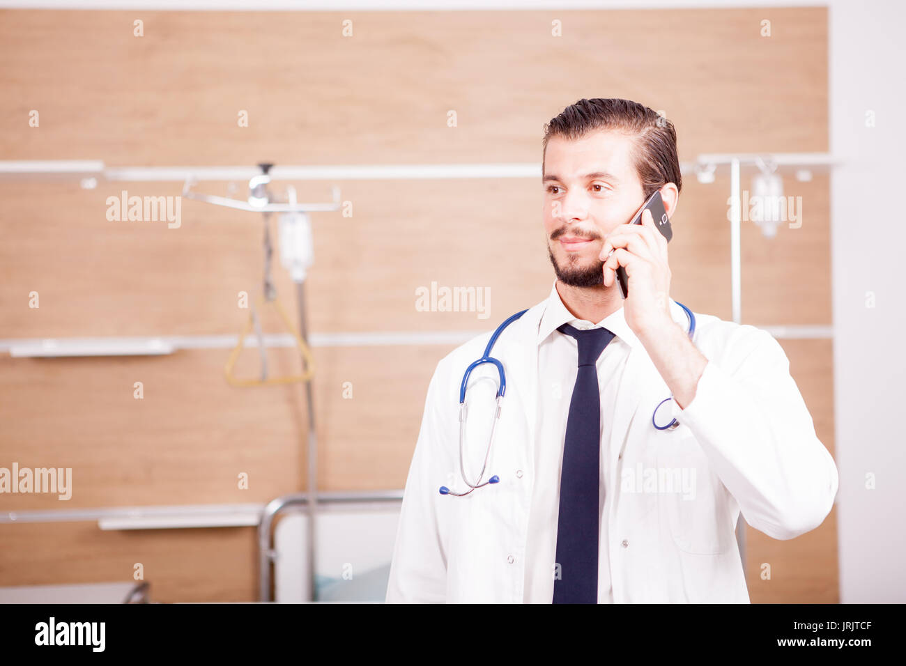 Doctor talking on the phone with stethoscope arround his neck in Stock ...