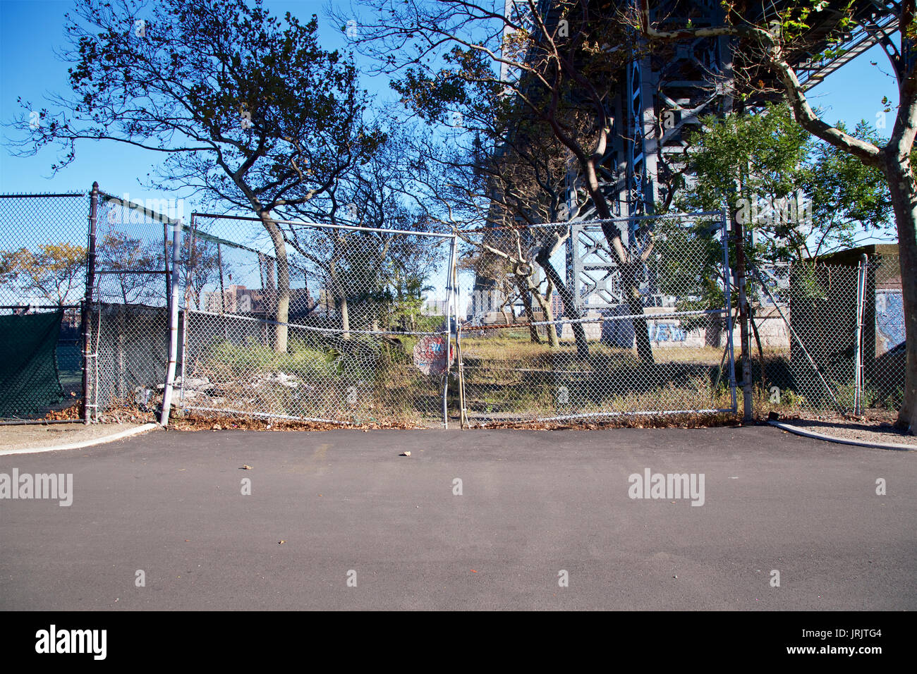 Battered, closed fence gate underneath the Williamsburg Bridge in ...