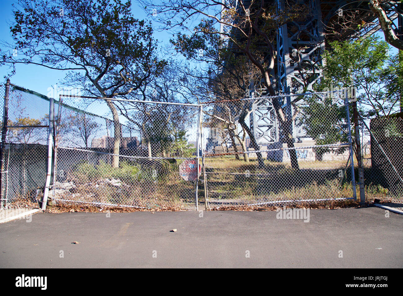 Battered, closed fence gate underneath the Williamsburg Bridge in ...