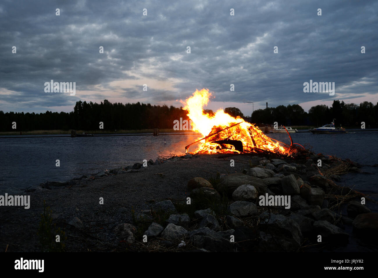 traditional bonfire on the summer solstice on the shore of the lake ...