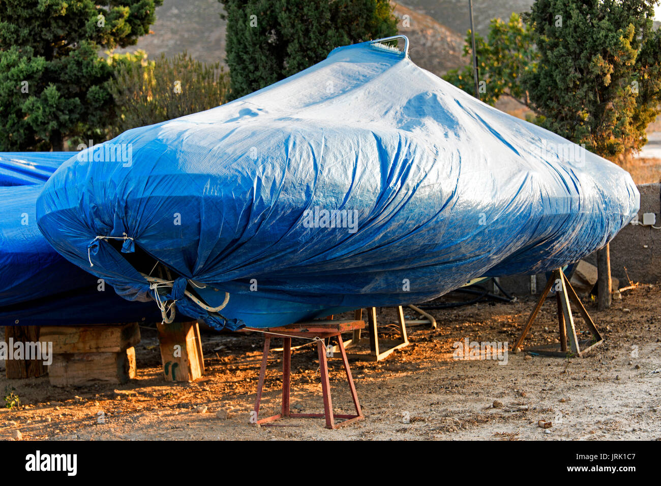 A covered boat lifted and parked Stock Photo - Alamy