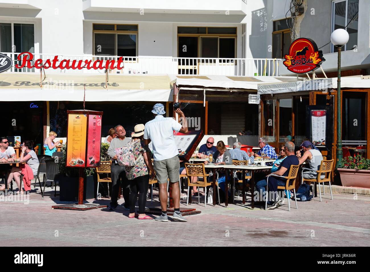 Tourists relaxing at a restaurant in Bugibba Square during the ...