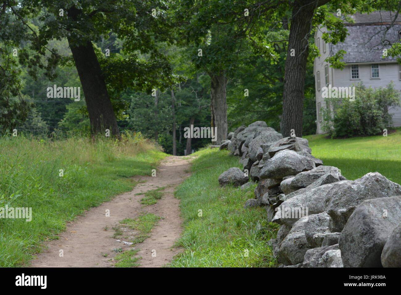 A dirt road and stone wall at the Concord National Historic Site near ...