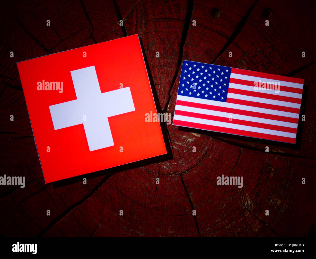 Swiss flag with USA flag on a tree stump isolated Stock Photo - Alamy