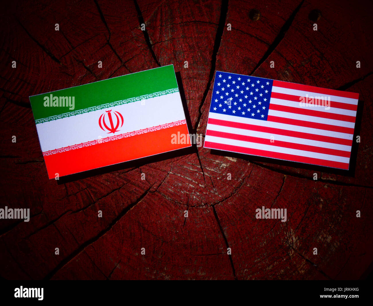 Iranian flag with USA flag on a tree stump isolated Stock Photo - Alamy