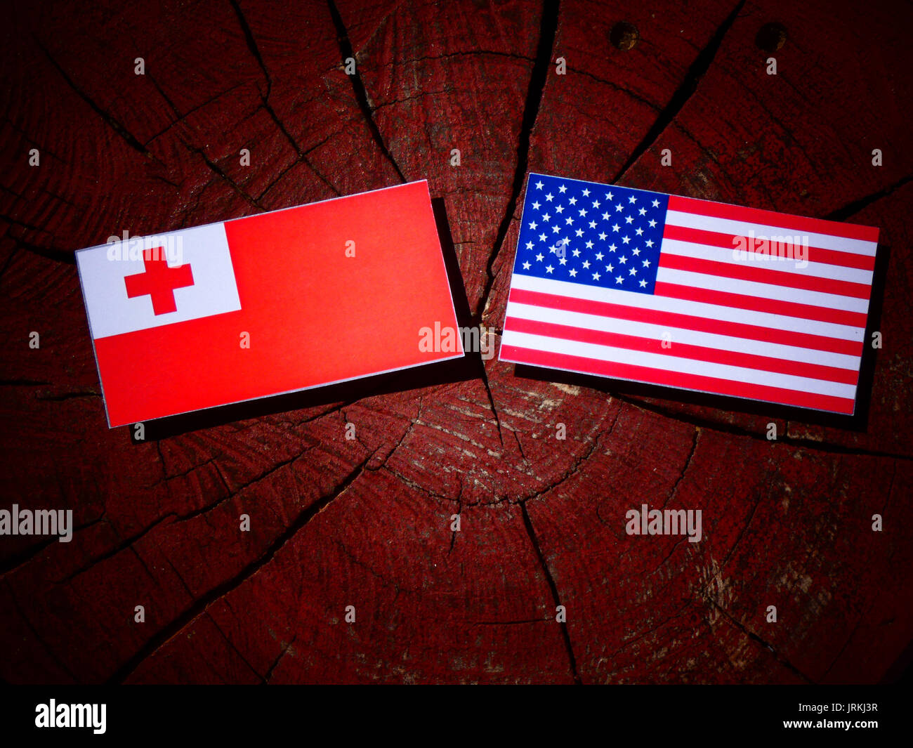 Tongan flag with USA flag on a tree stump isolated Stock Photo - Alamy