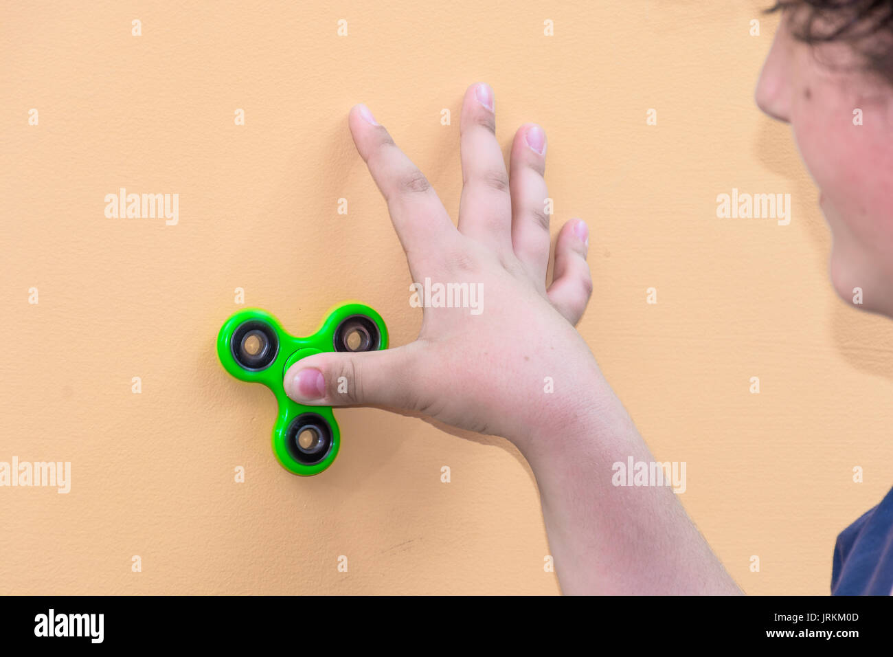 Boy playing with fidget spinner gadget. The fidget spinner is a toy, a ...