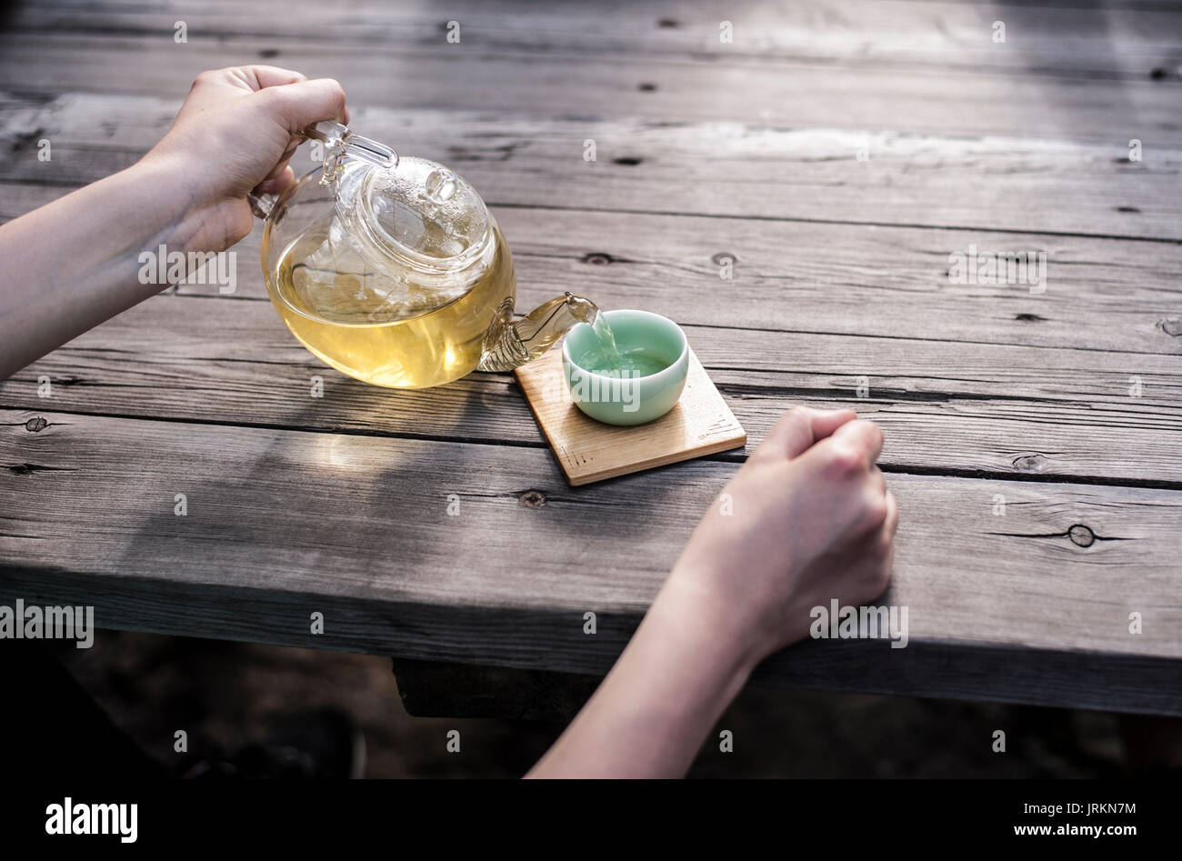 Traditional Chinese tea ceremony - woman holding glass tea pot pouring ...