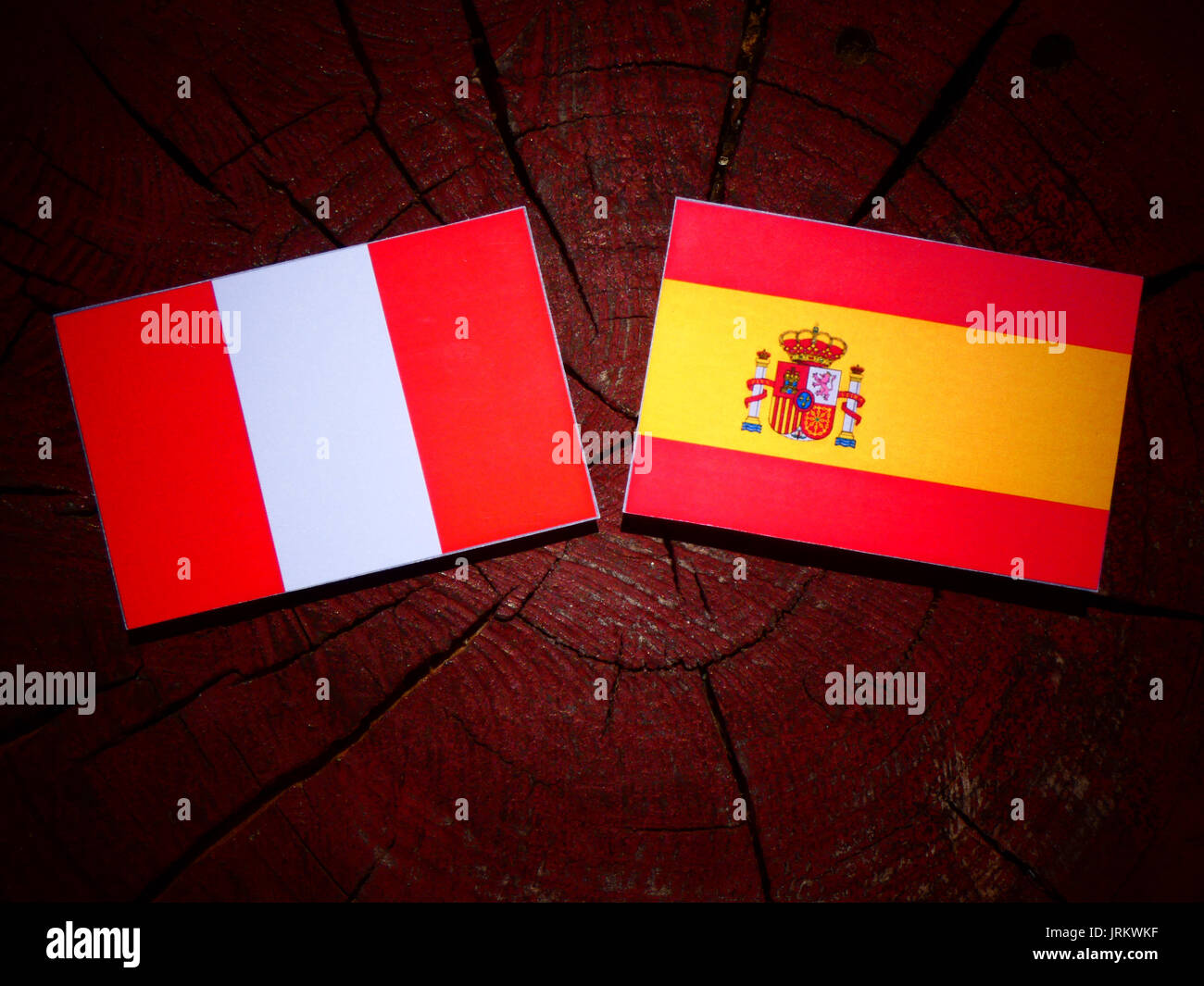 Peruvian flag with Spanish flag on a tree stump isolated Stock Photo ...