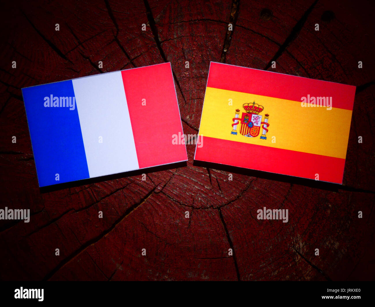 French flag with Spanish flag on a tree stump isolated Stock Photo - Alamy