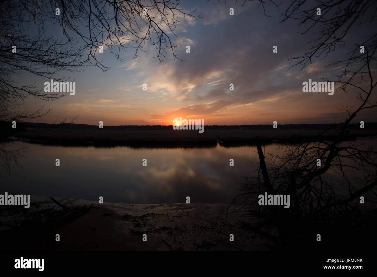 The evening sun begins to fall behind the horizon, casting vibrant ...