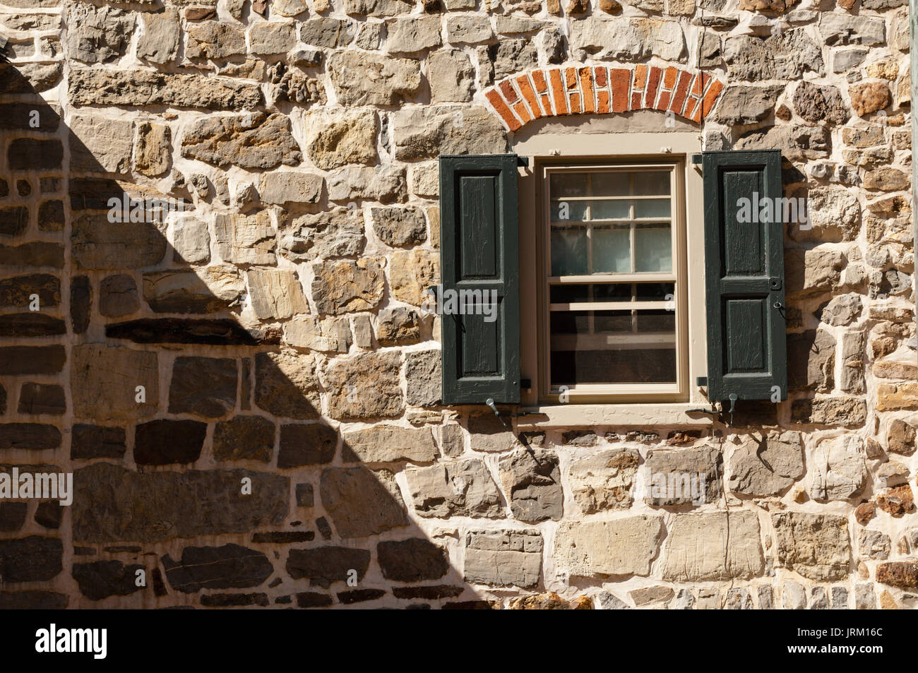 Single window with wooden shutters in colonial stone house with strong ...
