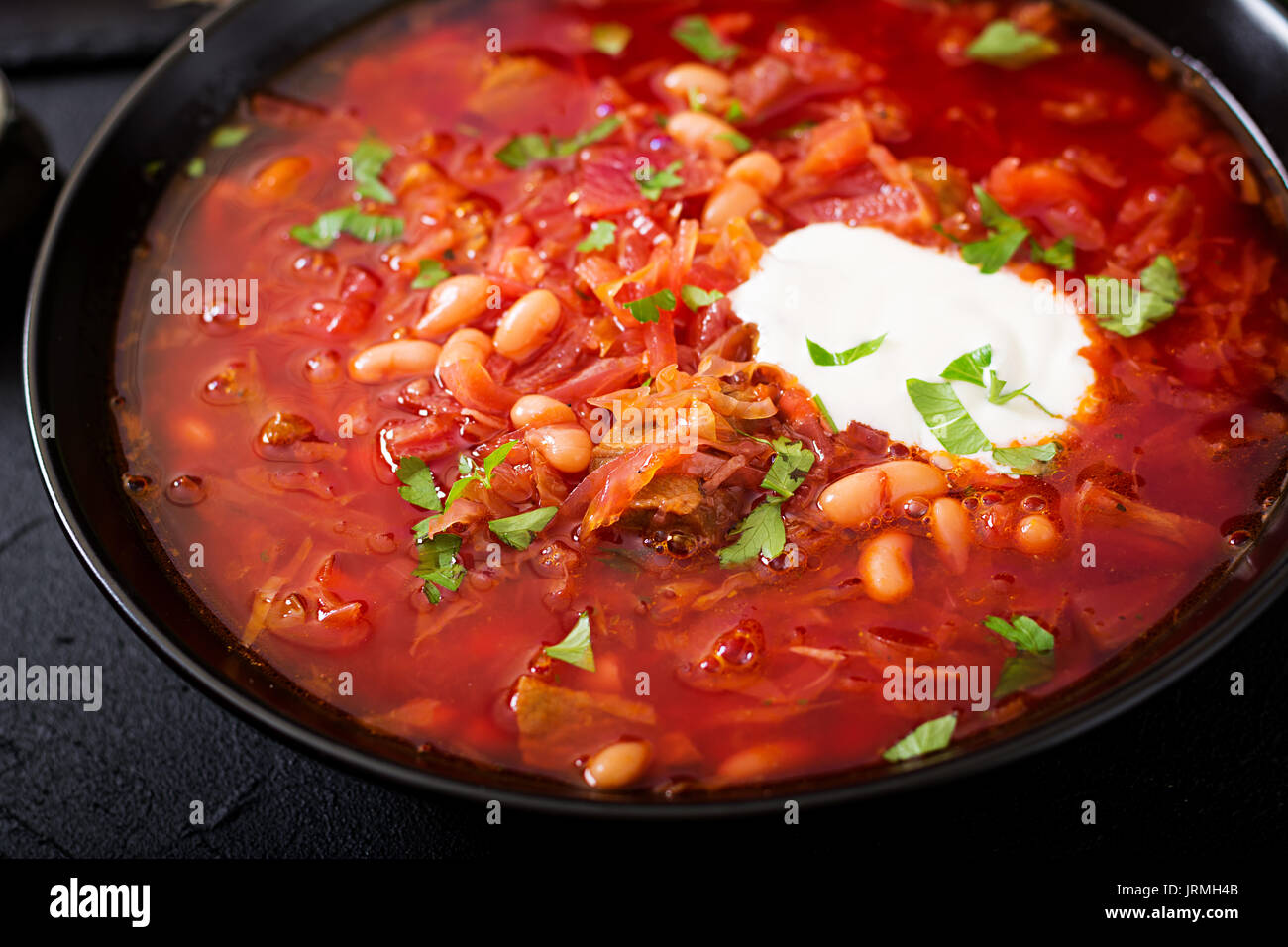 Traditional Ukrainian Russian borscht with white beans on the black ...