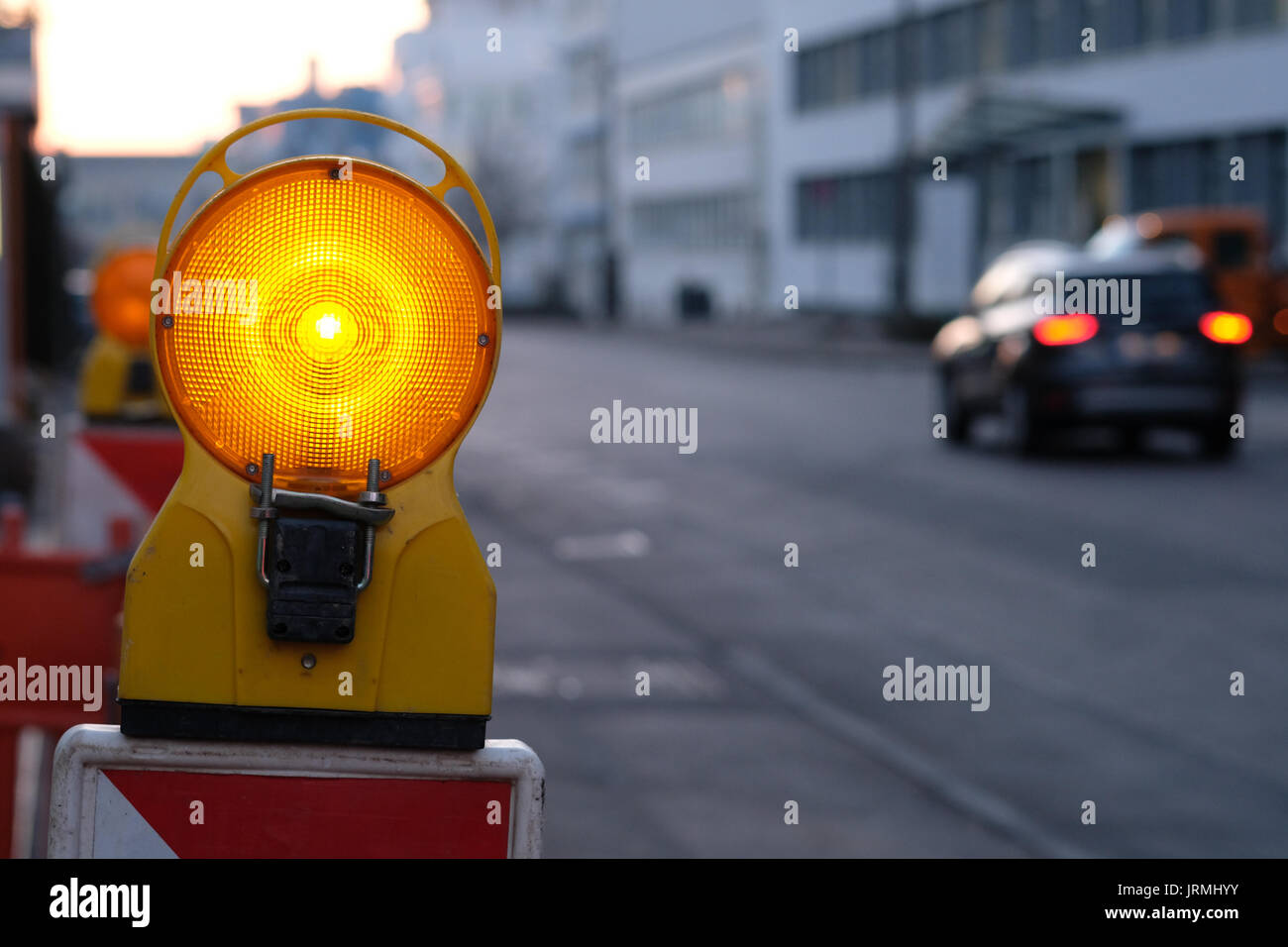 Warning lamp and cars with lights on a street Stock Photo - Alamy