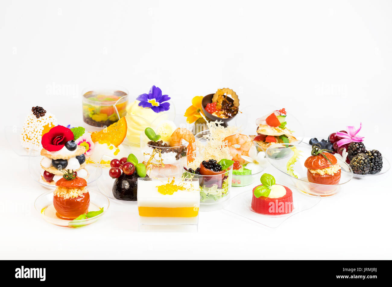 Mini desserts and meat canapes vegetable snacks in plastic cups canapes ...