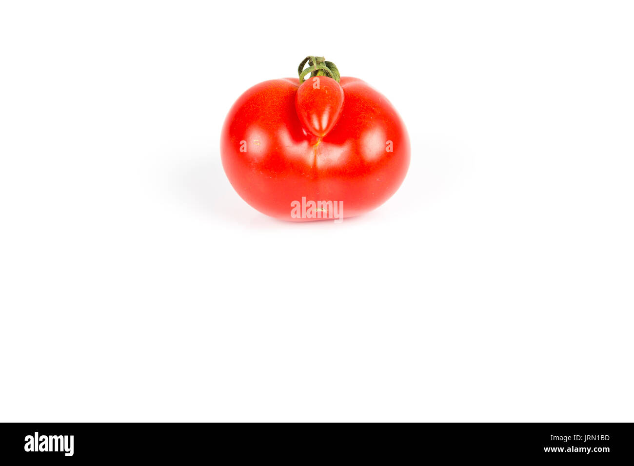 Deformed aberrant abnormal anomalous red tomato on a white background ...
