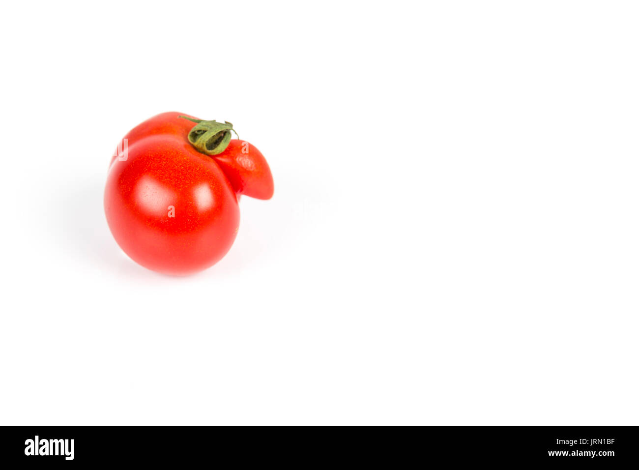 Deformed aberrant abnormal anomalous red tomato on a white background ...