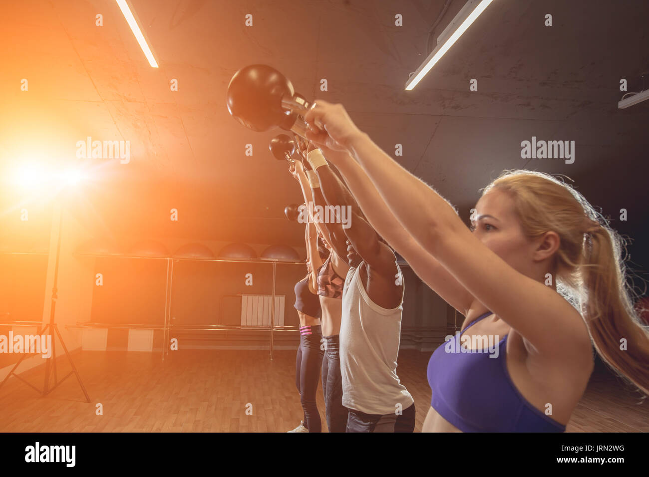Group having functional fitness training with kettlebell in sport gym ...
