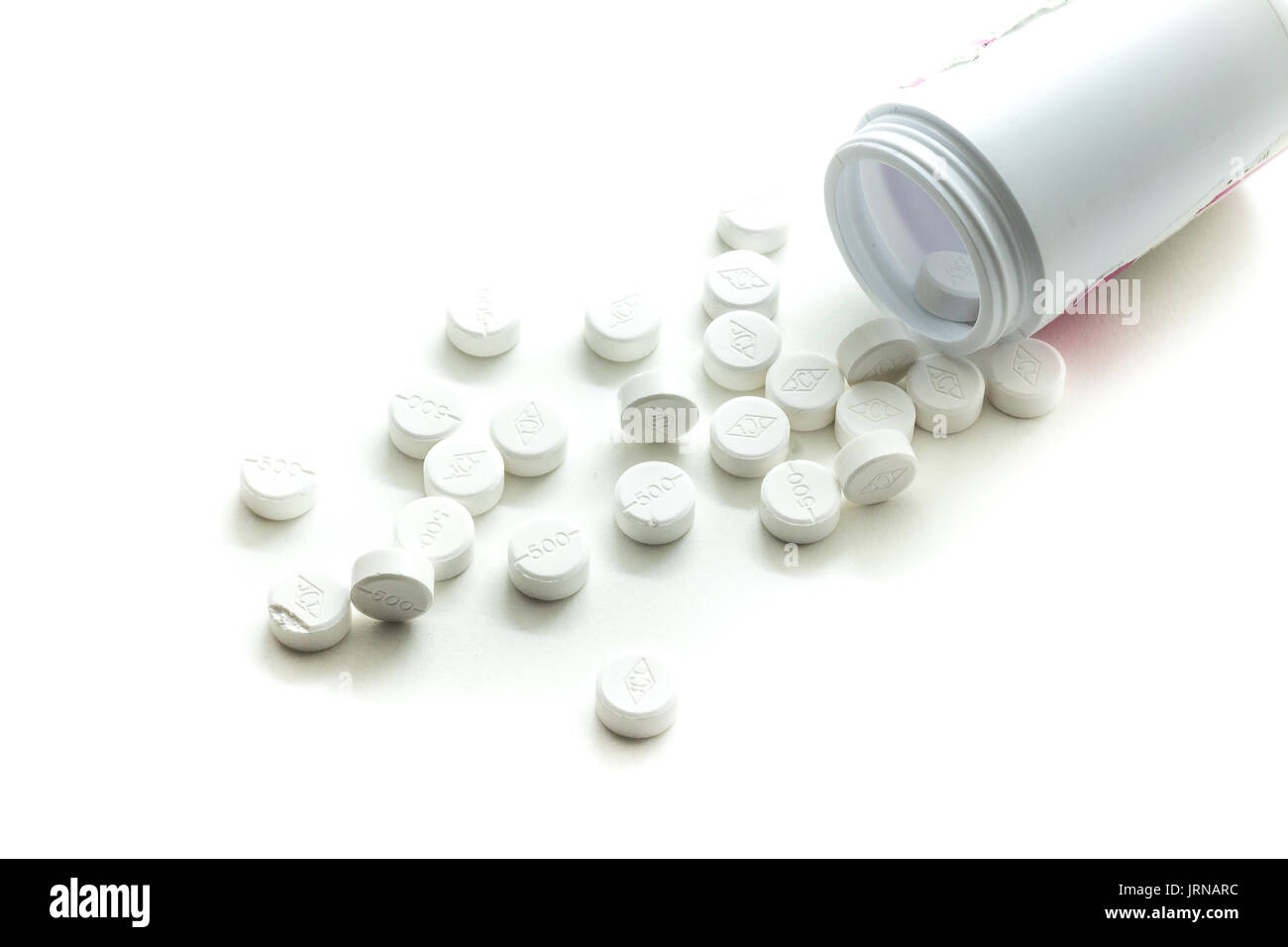 Pills spilling out of pill bottle Stock Photo - Alamy