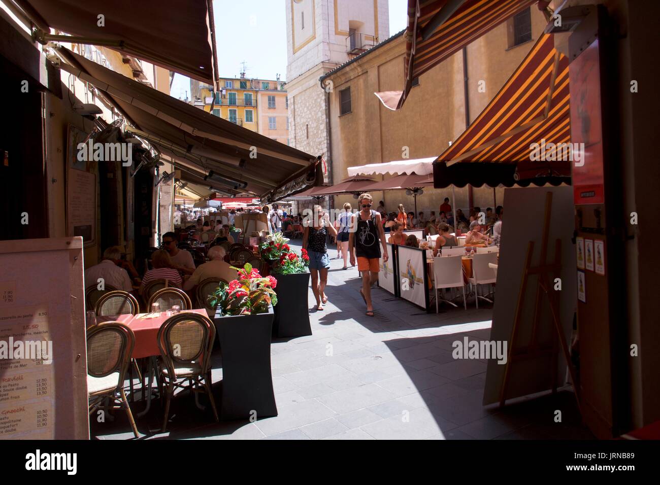 Tourist strolling past restaurants and pavement cafes, Nice, France ...