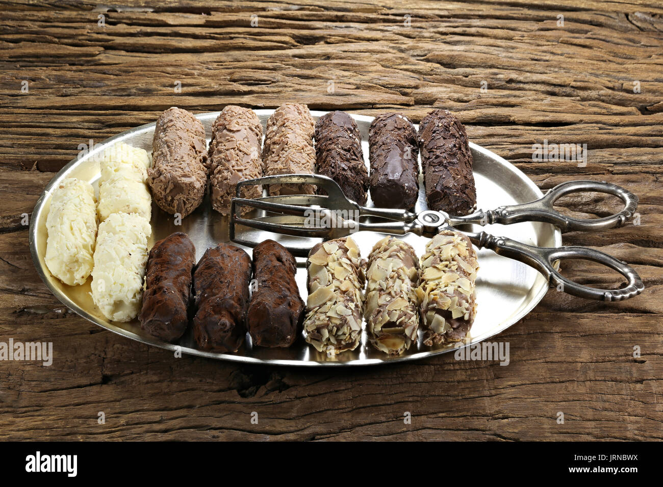 tray with handmade Belgian chocolate truffles and pastry tong on rustic ...