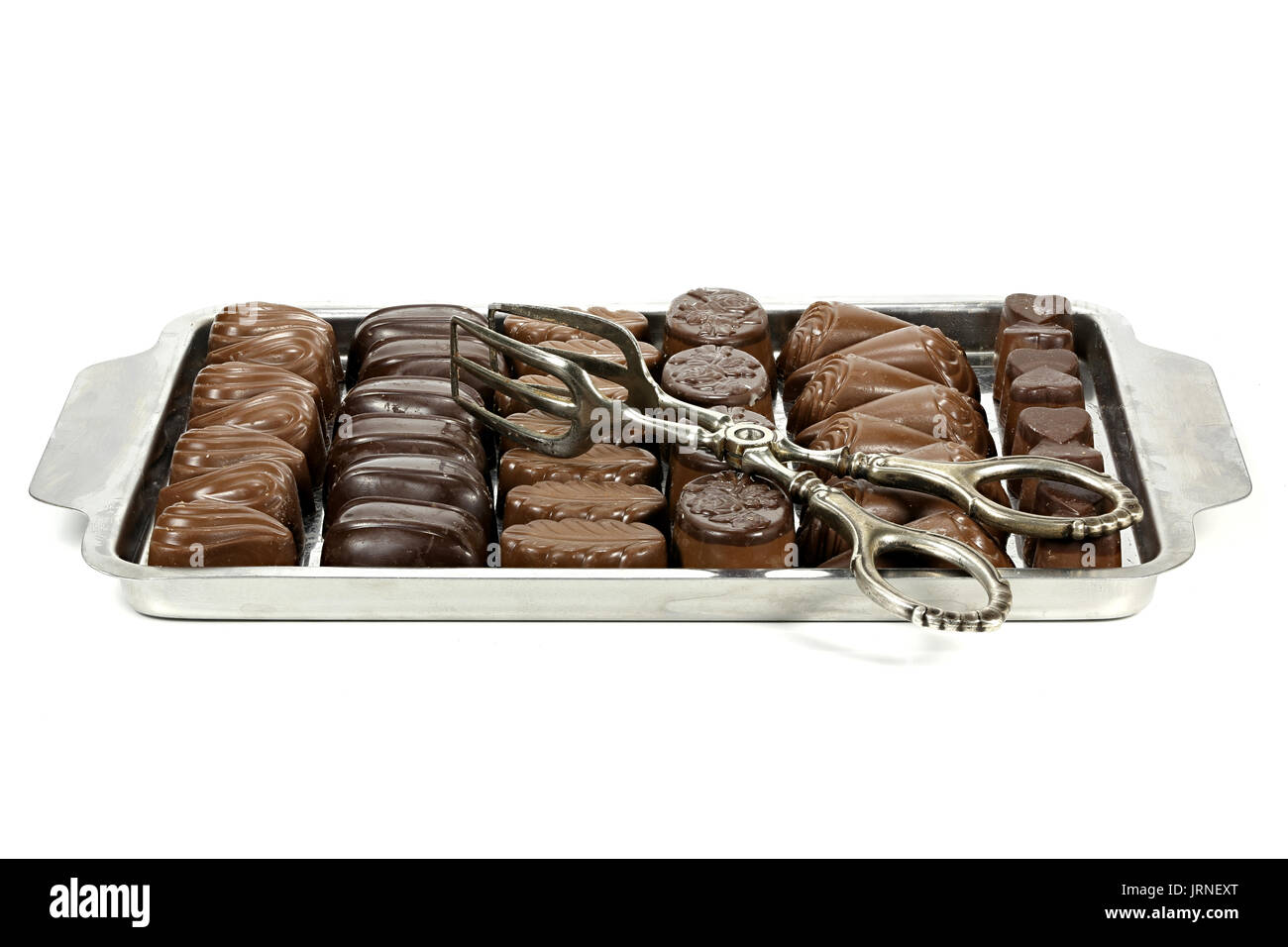 tray with Belgian chocolate pralines and pastry tong isolated on white ...