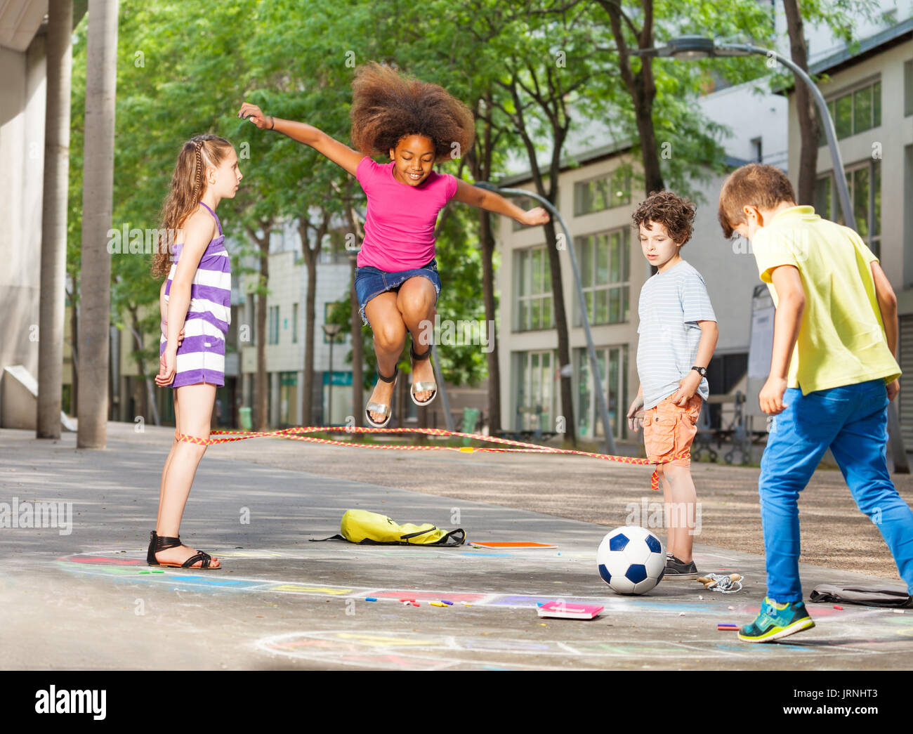 Group of kids elastic ropes together on the street Stock Photo - Alamy
