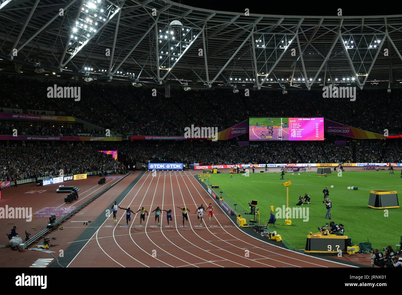 Competitors cross the finish line during the Men's 100m Final during ...