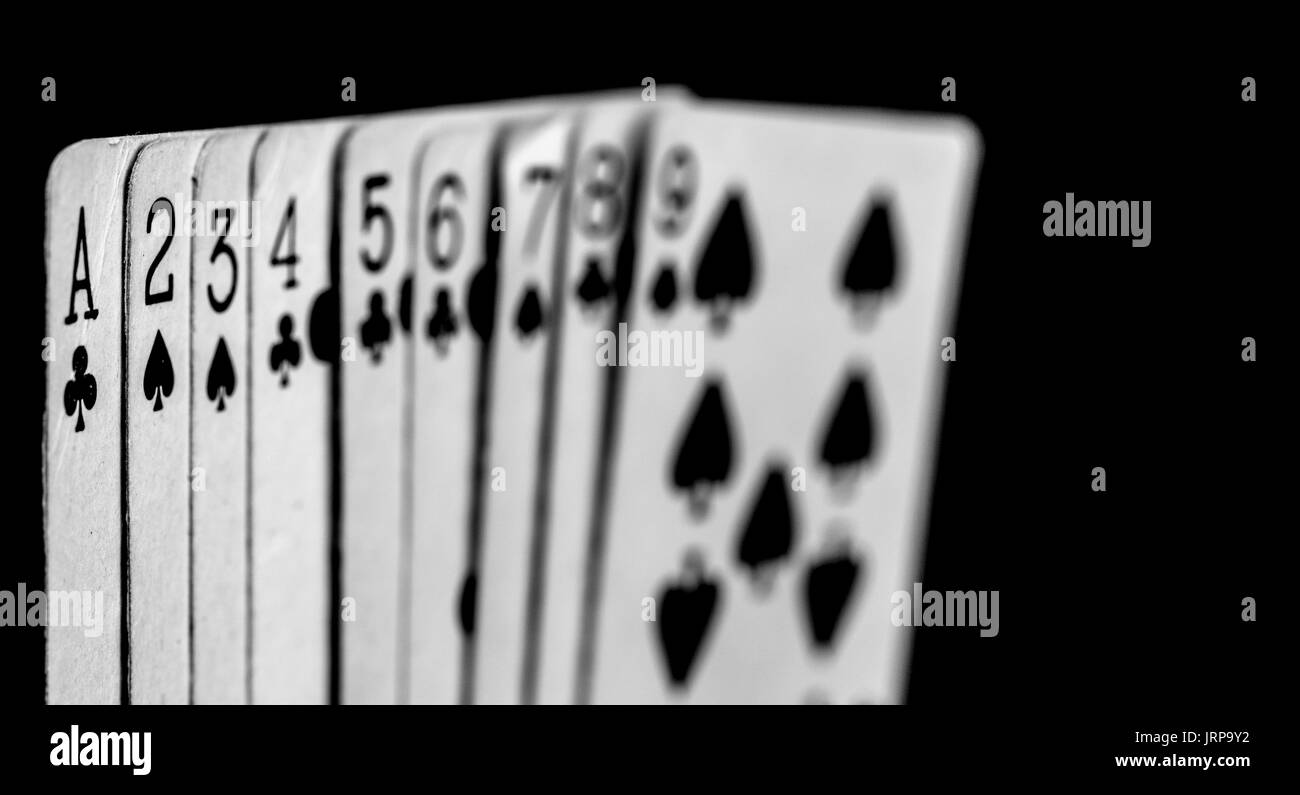 White playing cards with black symbols on a black background Stock ...