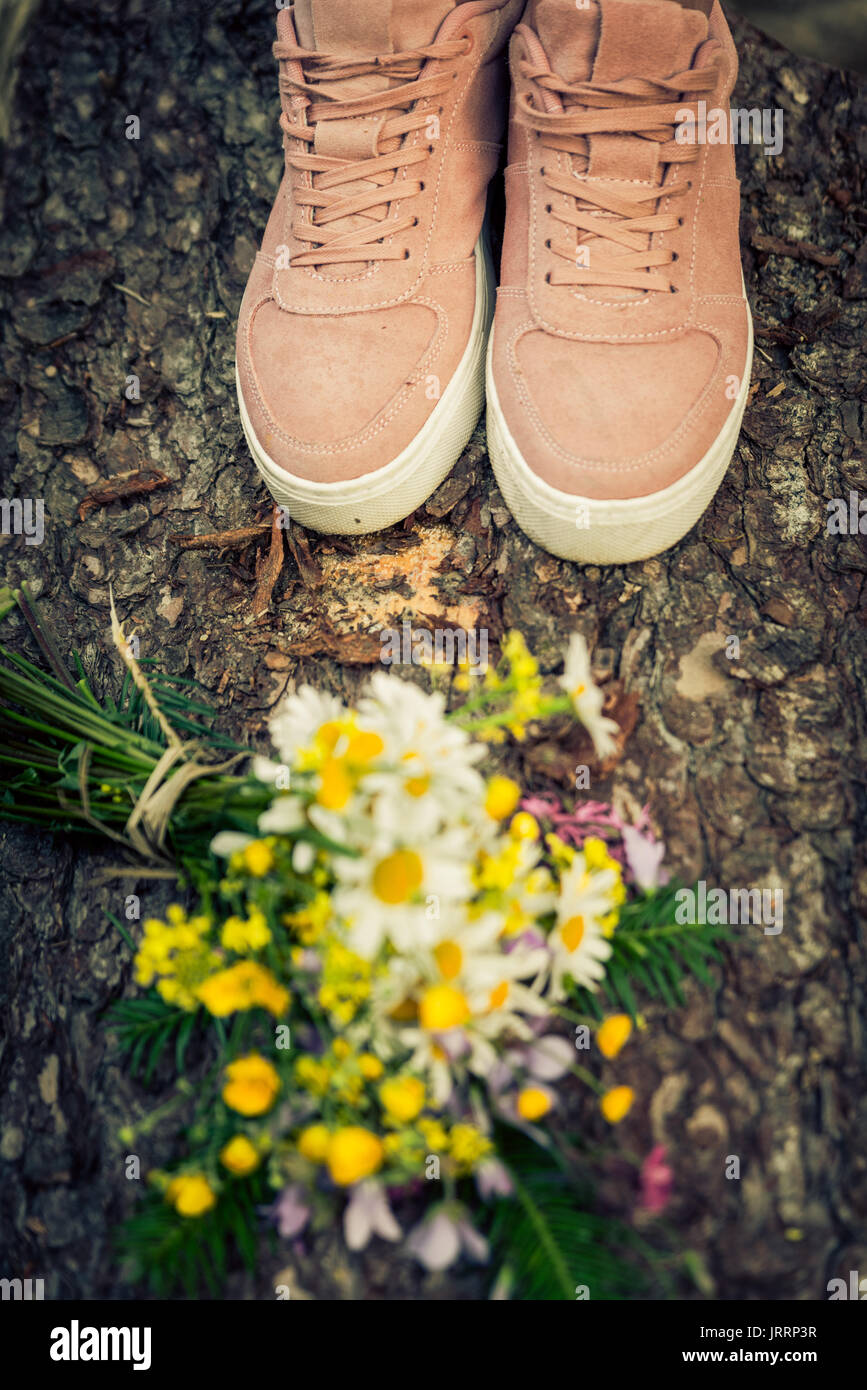 Beautiful bouquet of wildflowers spring flowers lying near female feet ...