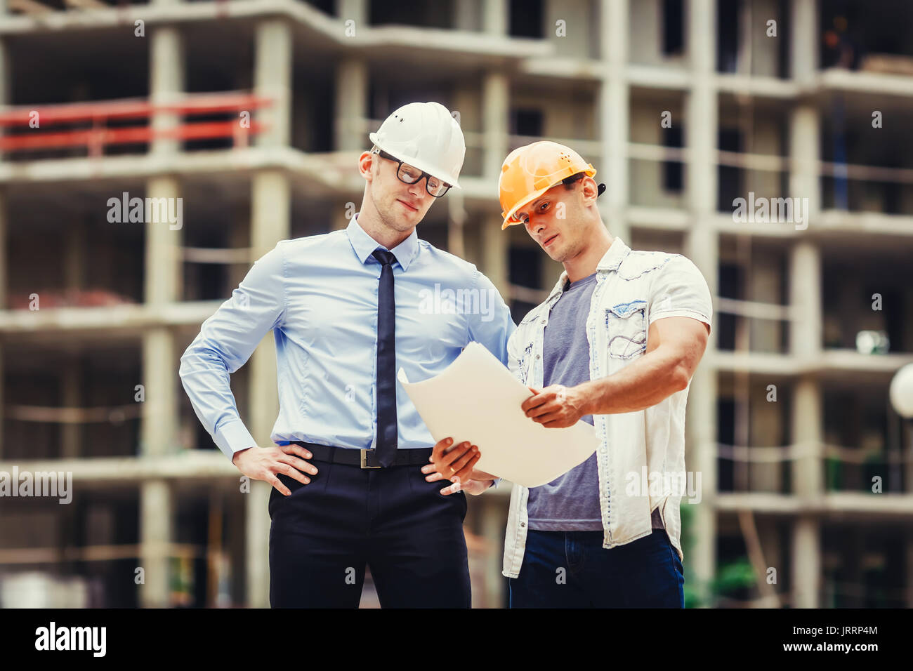 Architect and builder discussing at construction site Stock Photo - Alamy
