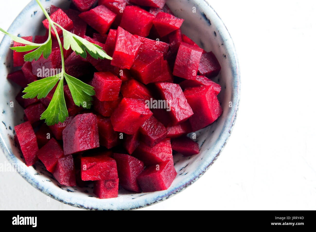 Beetroot (beet) chopped for salad in bowl over white background with ...