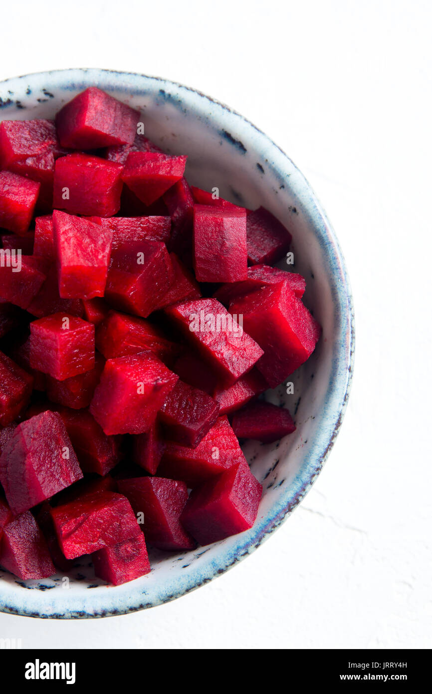 Beetroot (beet) chopped for salad in bowl over white background with ...