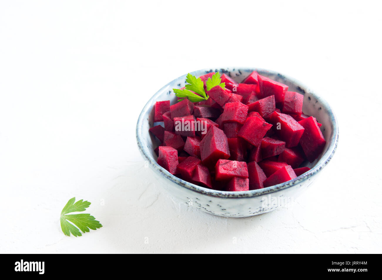 Beetroot (beet) chopped for salad in bowl over white background with ...