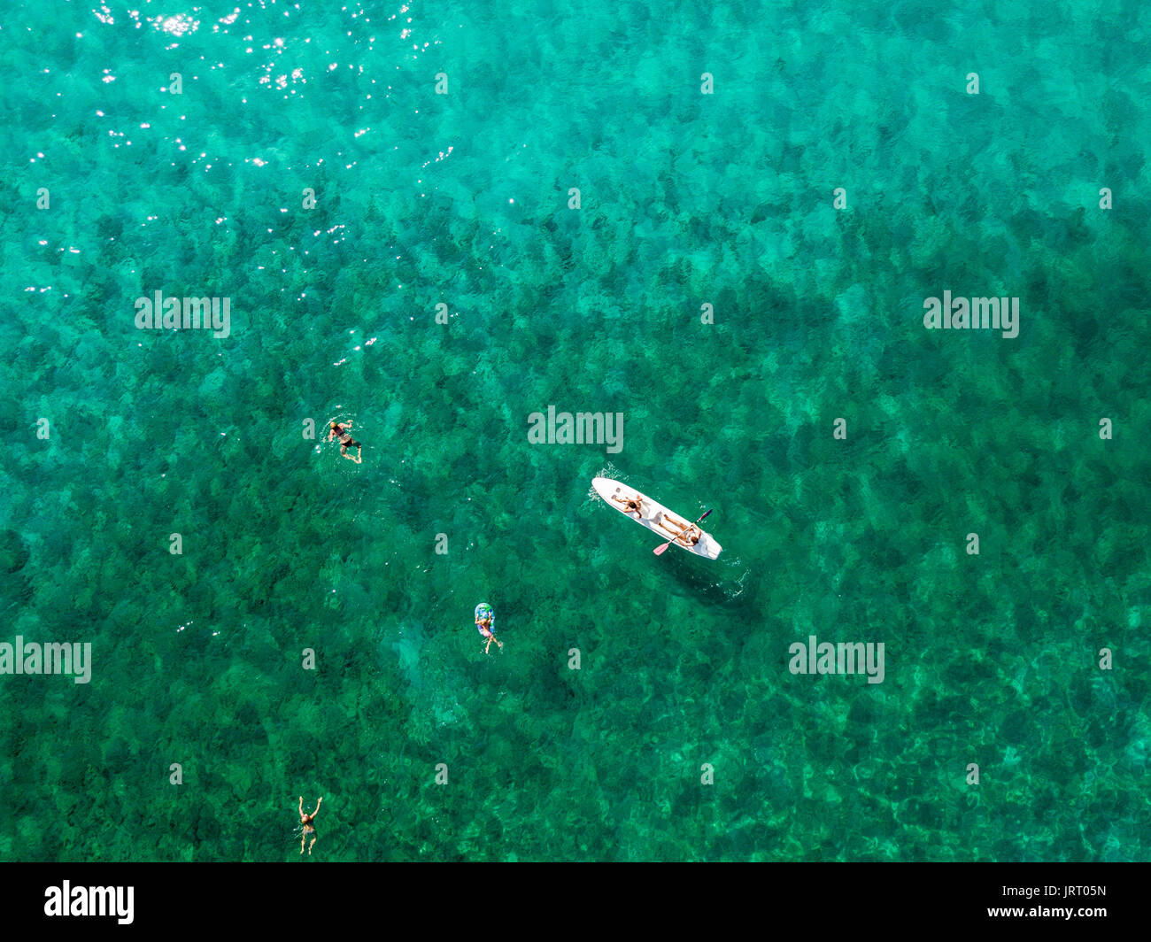 Aerial view of a canoe in the water floating on a transparent sea ...