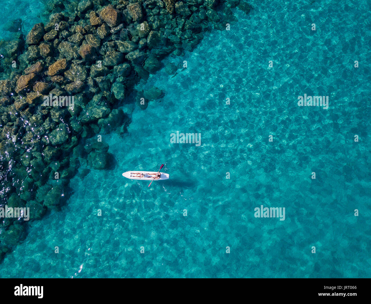Aerial view of a canoe in the water floating on a transparent sea ...