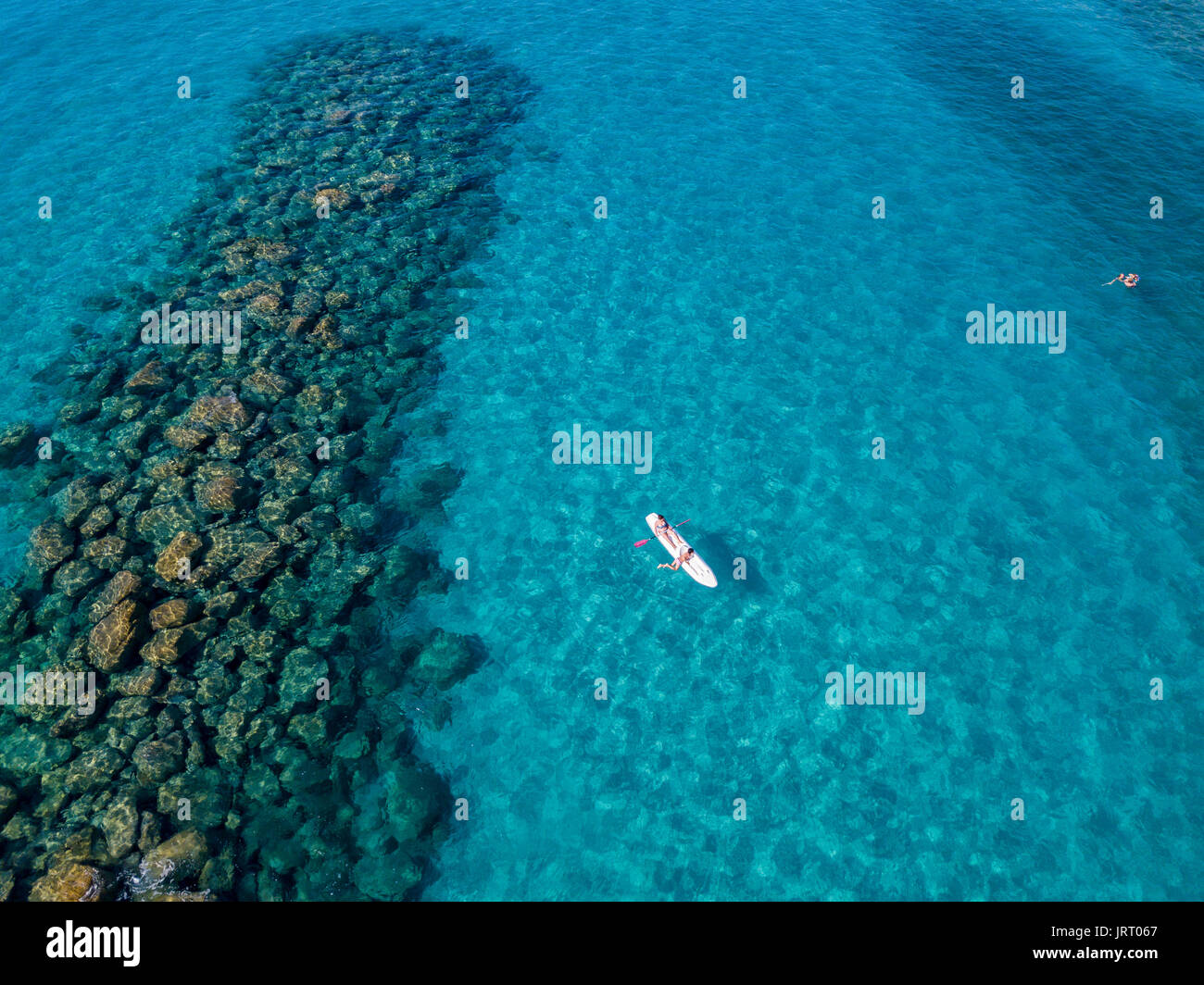 Aerial view of a canoe in the water floating on a transparent sea ...