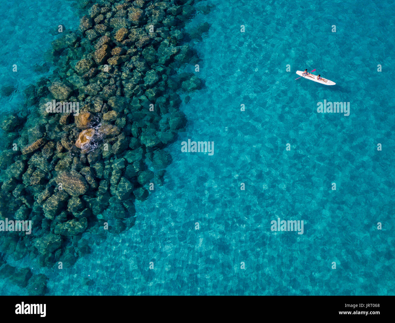 Aerial view of a canoe in the water floating on a transparent sea ...