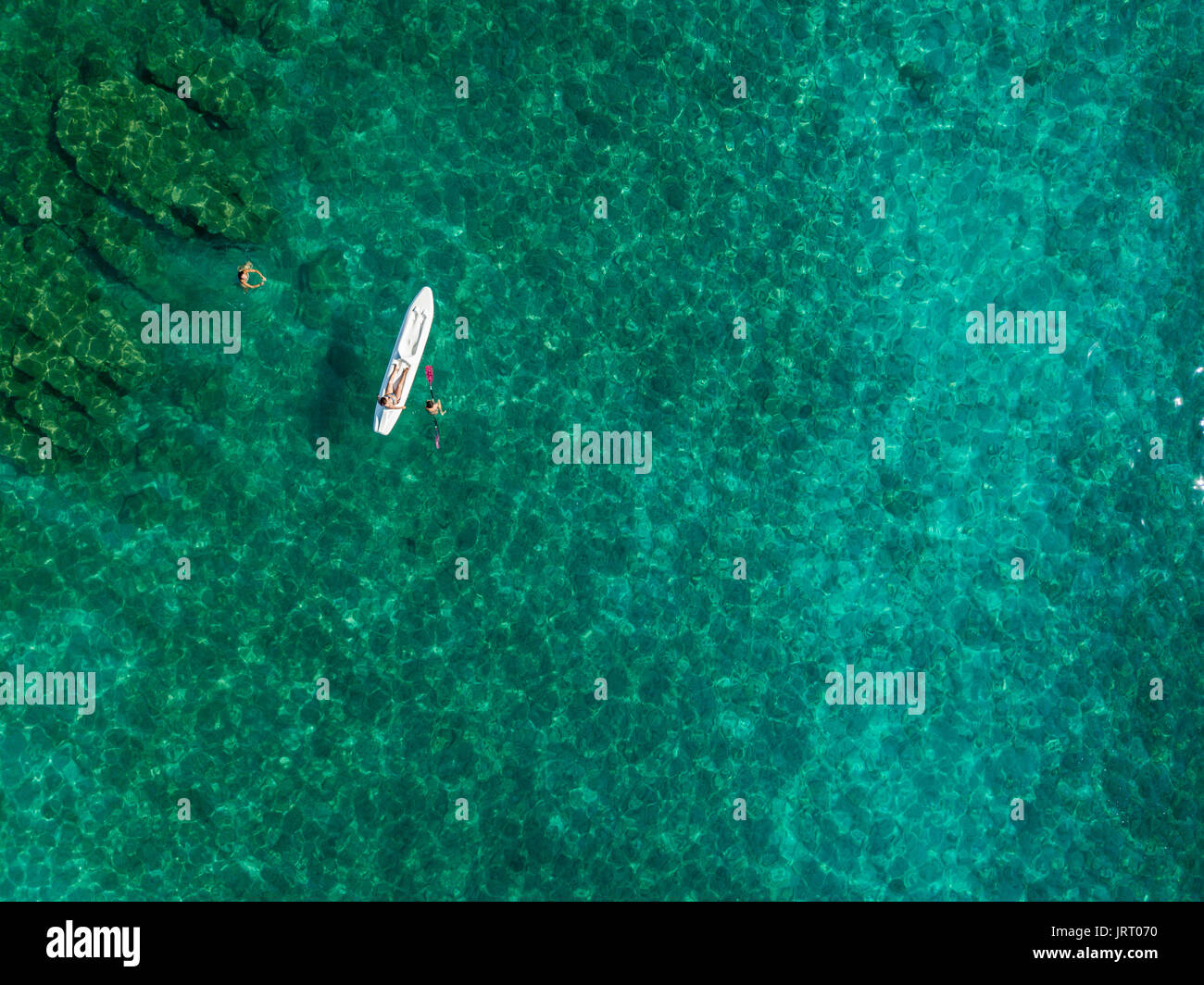 Aerial view of a canoe in the water floating on a transparent sea ...