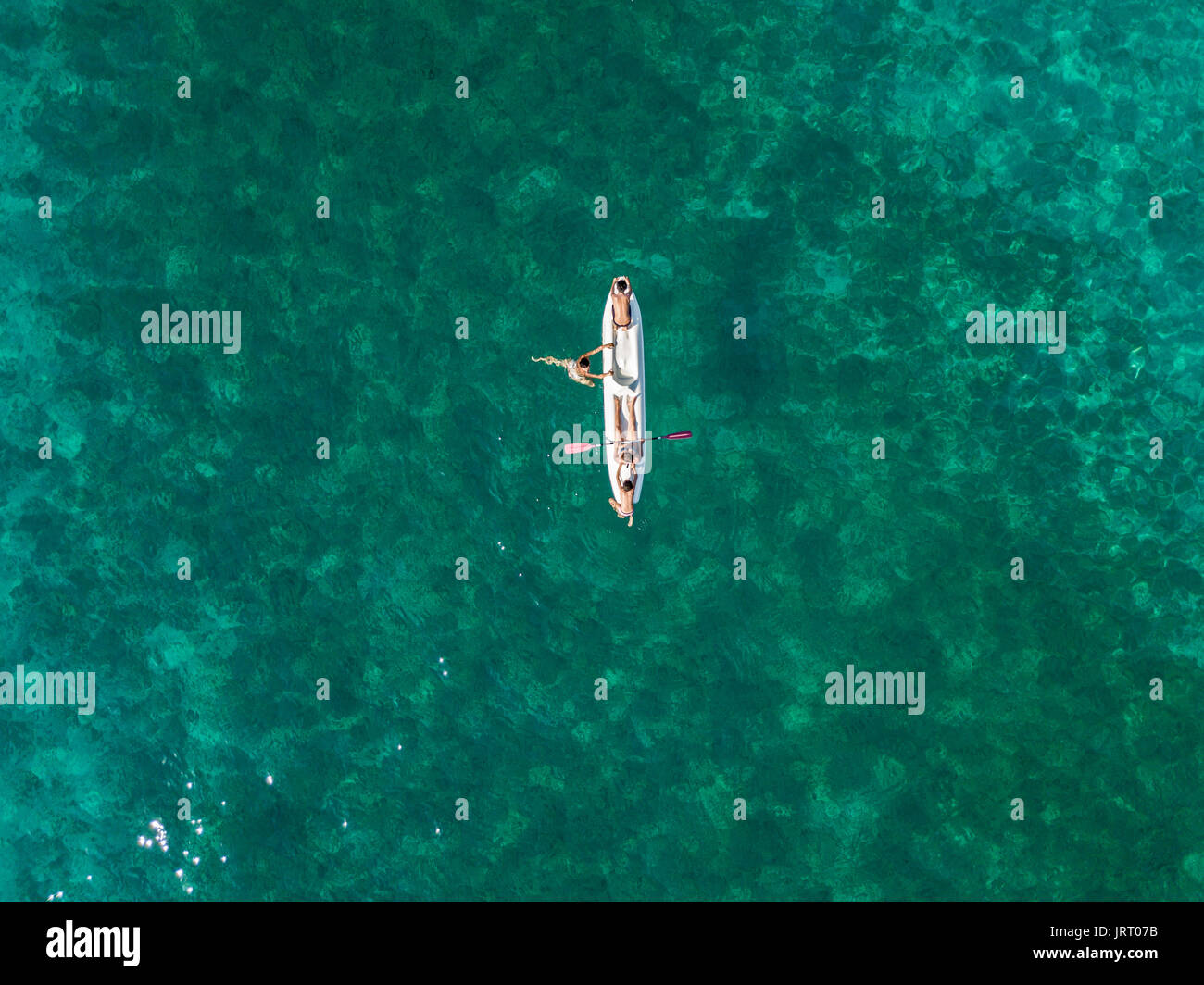 Aerial view of a canoe in the water floating on a transparent sea ...