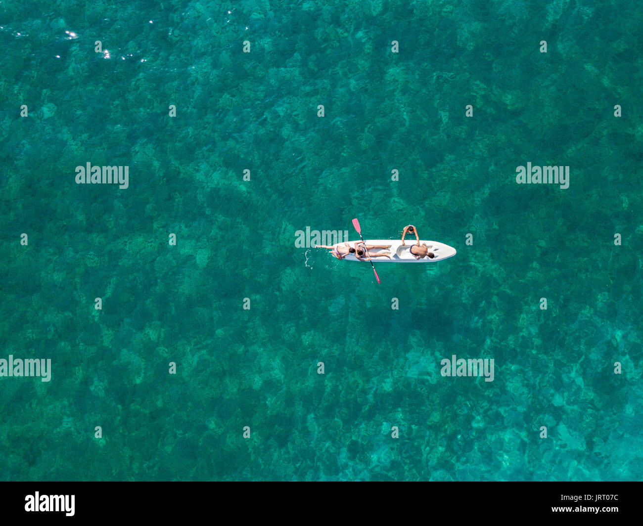 Aerial view of a canoe in the water floating on a transparent sea ...