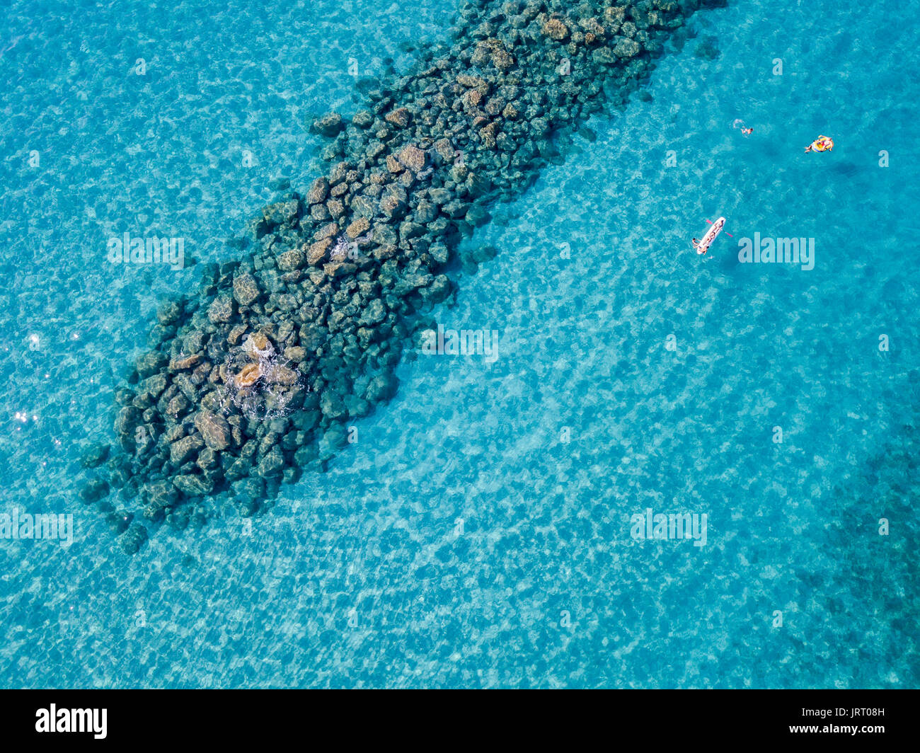 Aerial view of a canoe in the water floating on a transparent sea ...