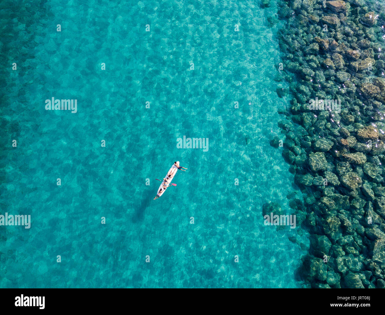 Aerial view of a canoe in the water floating on a transparent sea ...