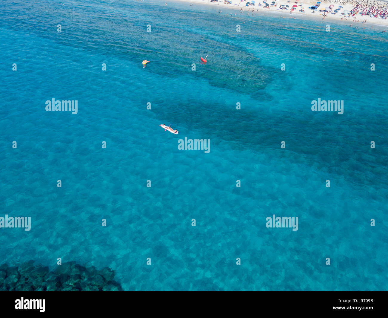 Aerial view of a canoe in the water floating on a transparent sea ...