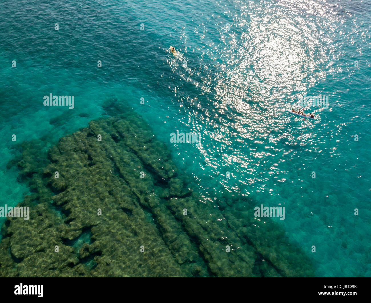 Aerial view of a canoe in the water floating on a transparent sea ...